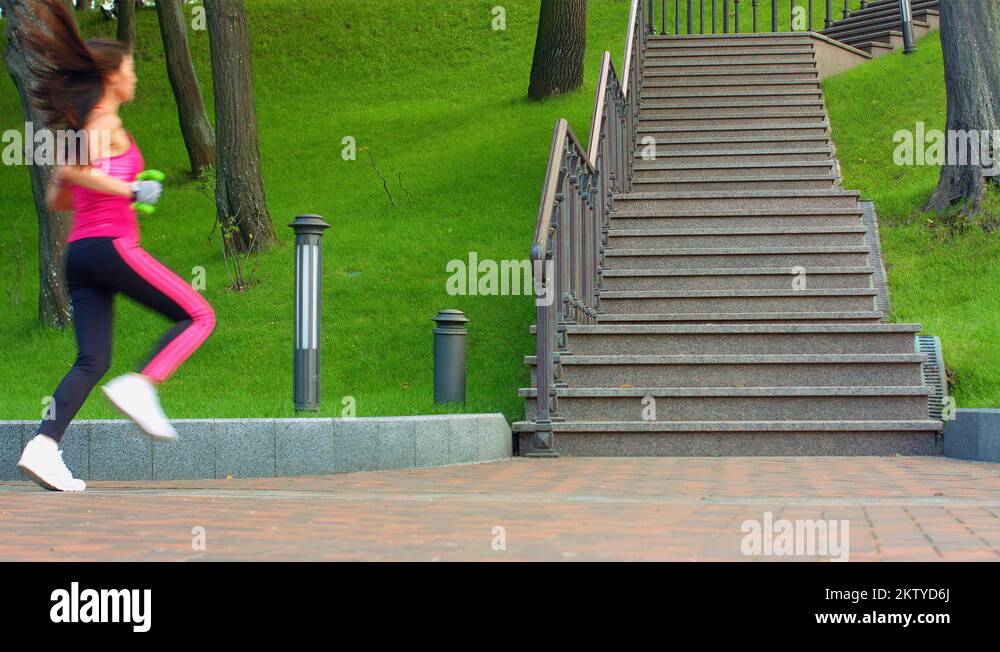Girl running up stairs at park. Woman stairs. Young woman running ...
