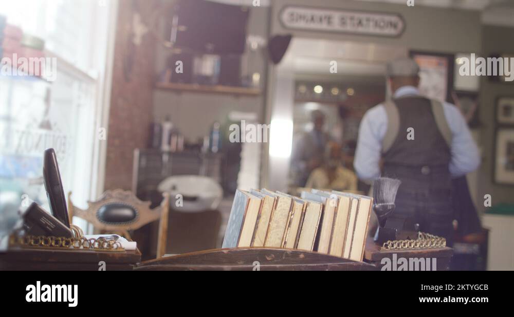 4K Portrait of smiling barbers behind reception desk in trendy retro ...