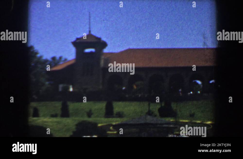 1964: a well-kept lawn, studded with trees, in front of a large ...