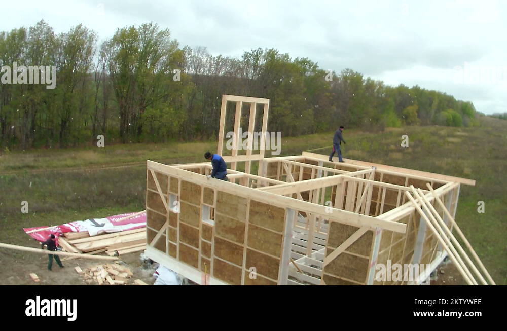 Country house of straw bales construction. Workers make the ceiling on ...