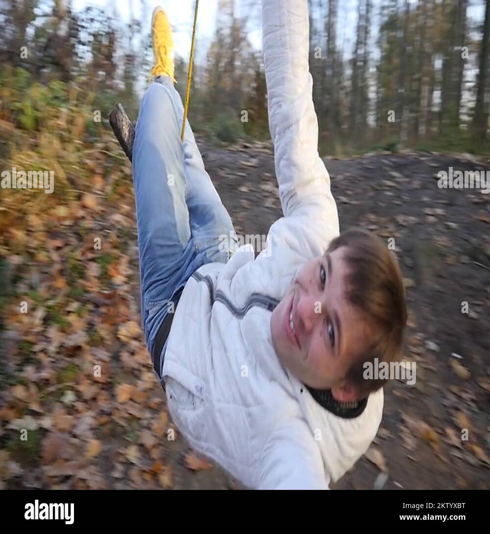 Man father funny sway on hanging from a tree suspended rope swing in ...