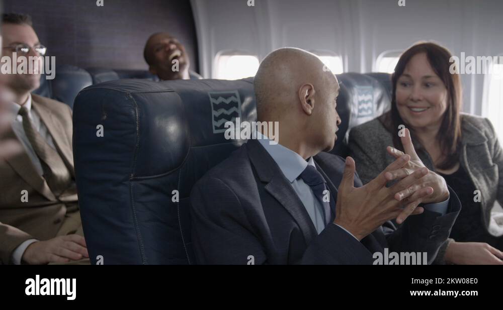 Flight attendant serves water to airline passengers in First Class ...