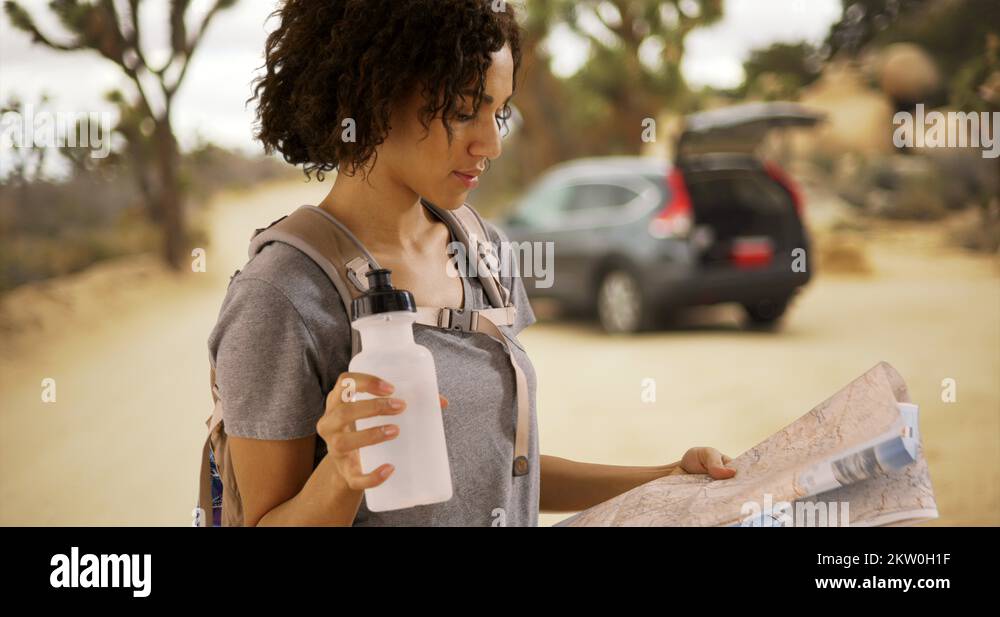 Lost female hiker looking at map of Mojave Desert, Joshua Tree ...