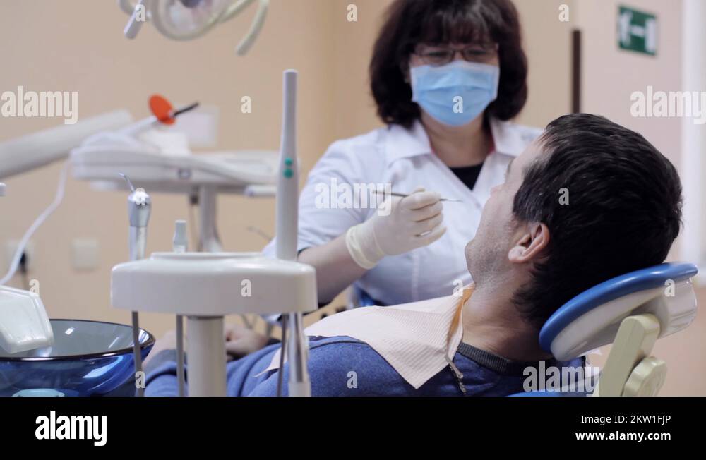 Dentist checks teeth of male patient by dental mirror Stock Video ...