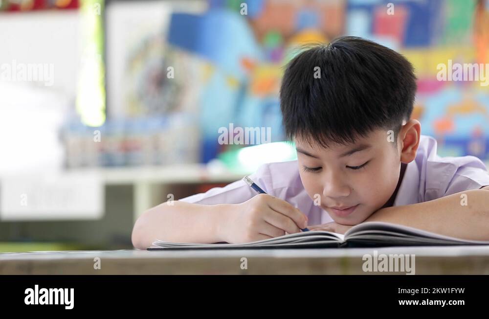 Asian child in student uniform reading and writing Stock Video Footage ...