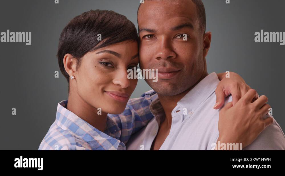 African American Couple Pose For A Portrait On A Grey Gradient