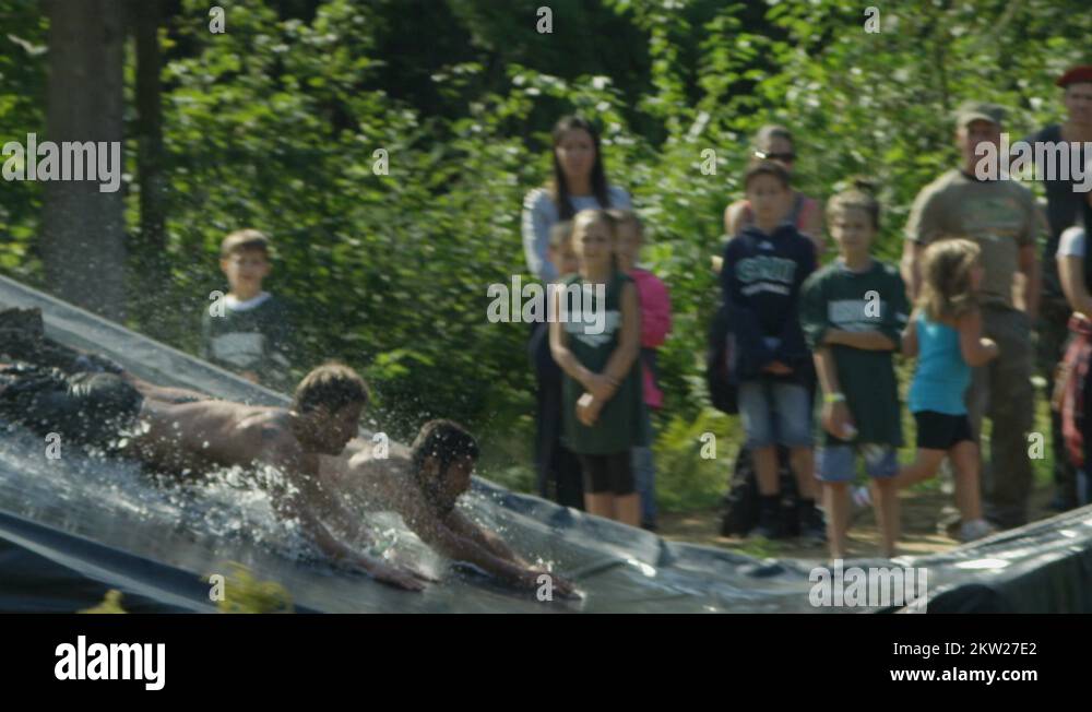 Obstacle race - two men on water slide slow motion Stock Video Footage ...