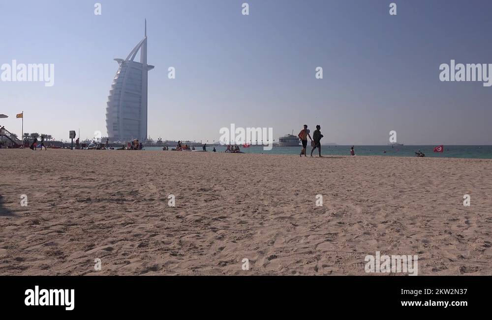 People in Dubai beach walk on shoreline seaside landscape Burj al Arab ...