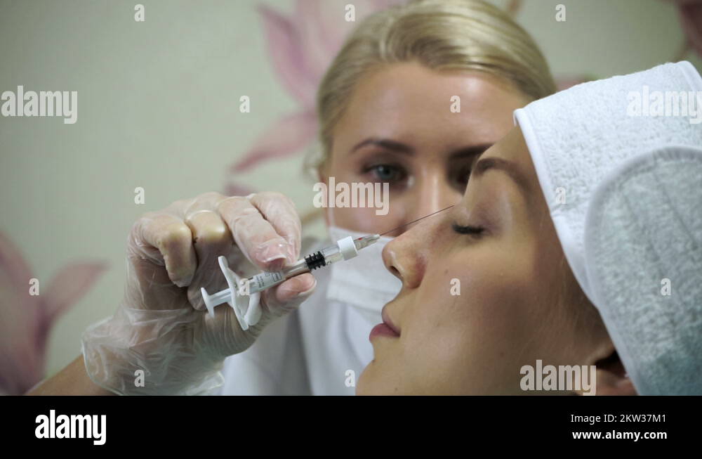 Correction of shape of a nose. The doctor checks the line of girl's ...