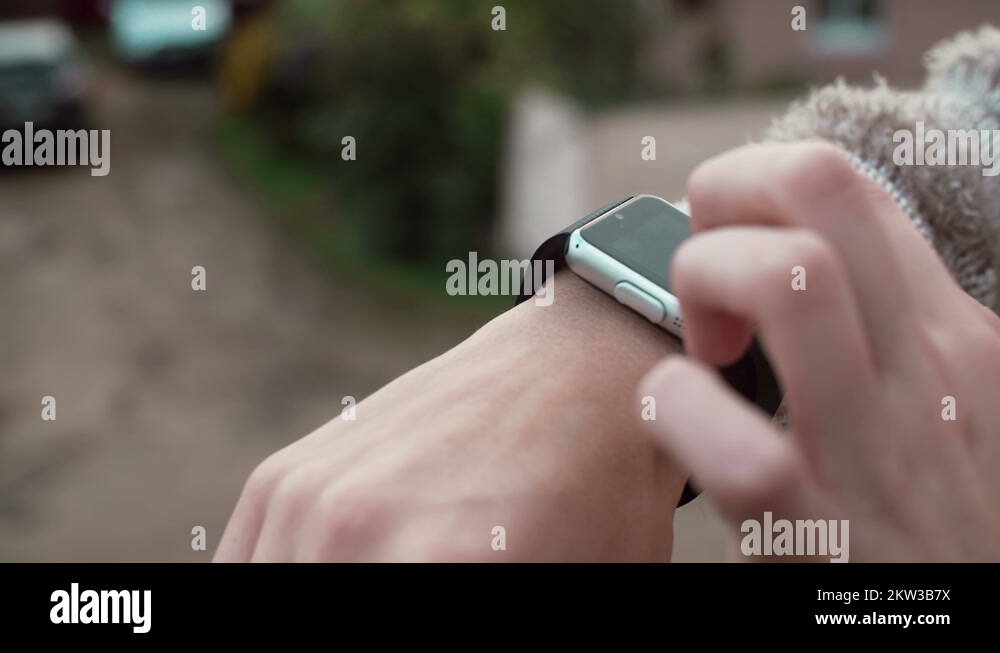 Woman using her smartwatch touchscreen device on a countryside ...