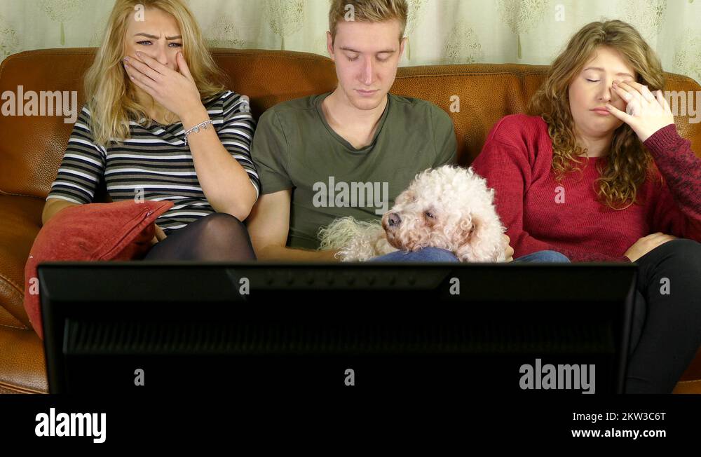 Three friends watching TV and reacting to an upsetting moment Stock ...