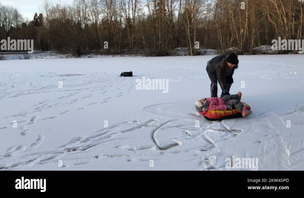 Dad Pushes Her Daughter On A Rubber Inflatable Snow Tube Stock Video Footage Alamy