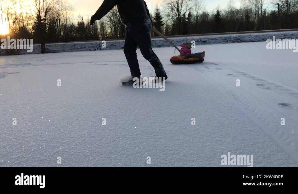 Dad Pushes Her Daughter On A Rubber Inflatable Snow Tube Stock Video Footage Alamy