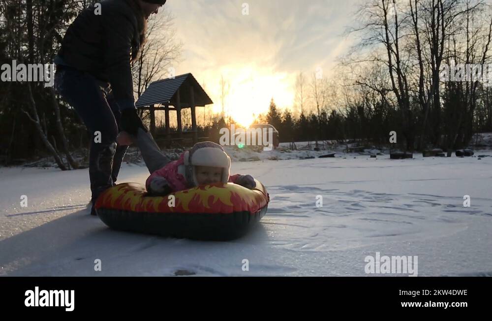 Dad Pushes Her Daughter On A Rubber Inflatable Snow Tube Stock Video Footage Alamy