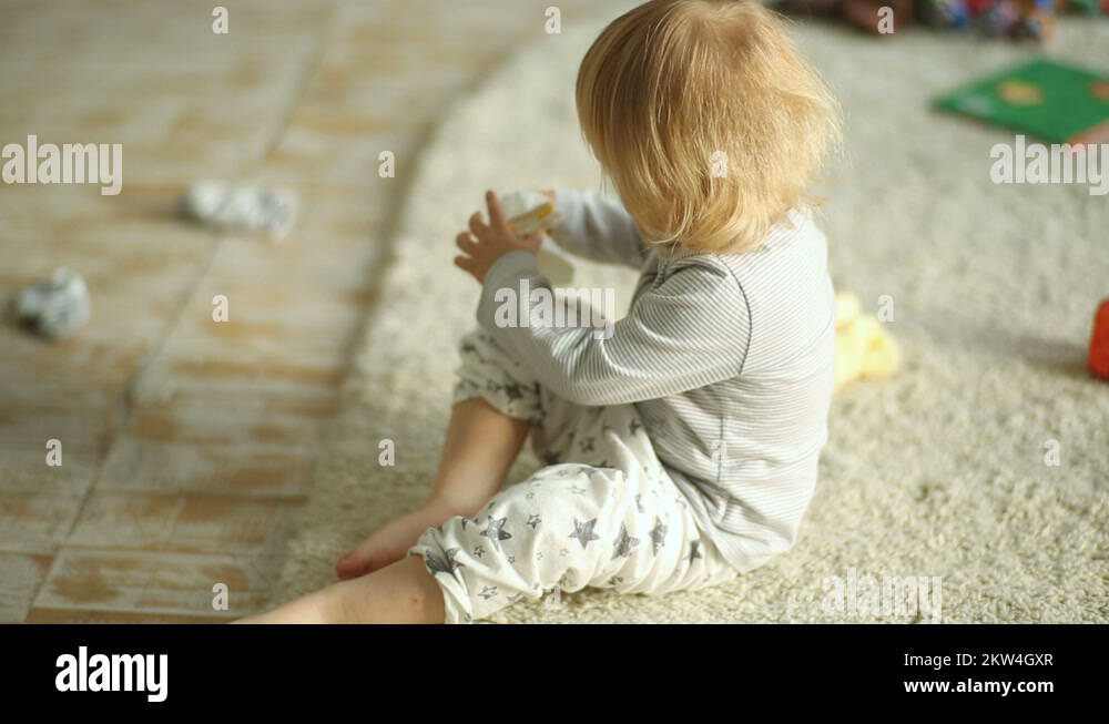 Little blonde girl trying to put socks on Stock Video Footage - Alamy