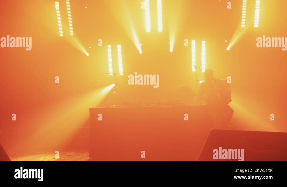 Flashing red projector light scene and sitting man with accordion at ...