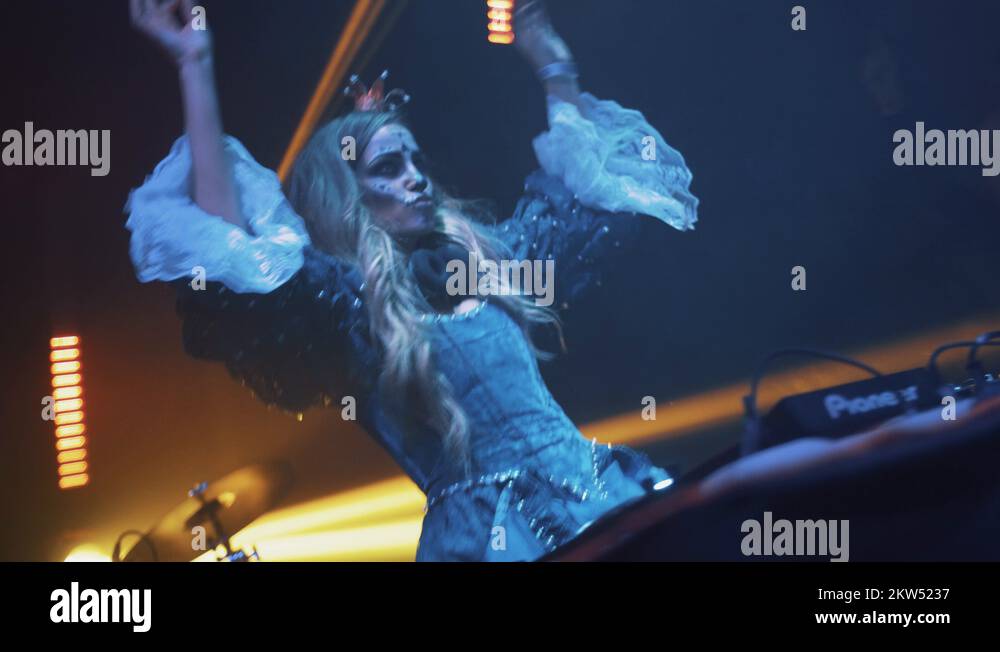 DJ girl in halloween princess costume and santa muerte face paint dance ...