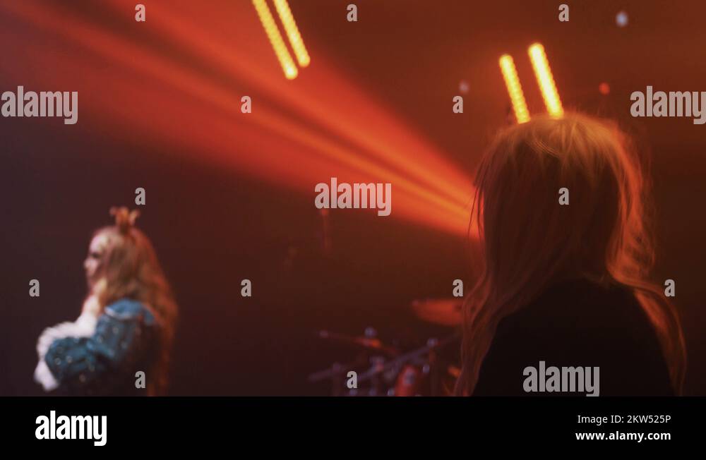 Woman in white wig dance on scene with moving and flashing lights on ...
