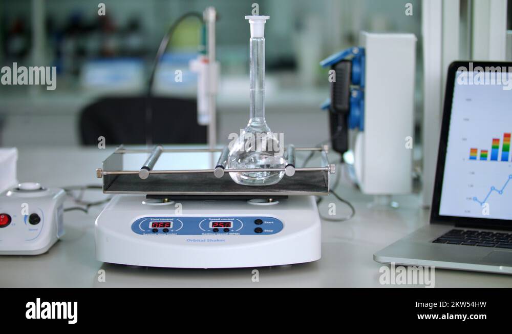Laboratory equipment in modern lab. Pure liquid mixing in glass flask ...