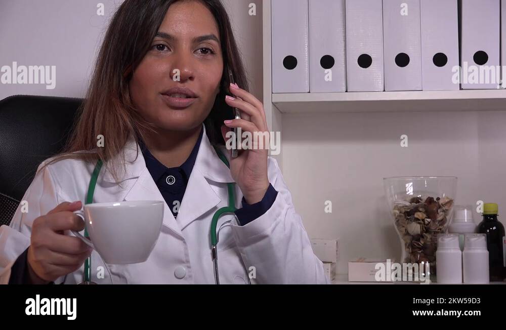 Latina doctor with stethoscope drinking coffee tea talking to patient medication Stock Video ...