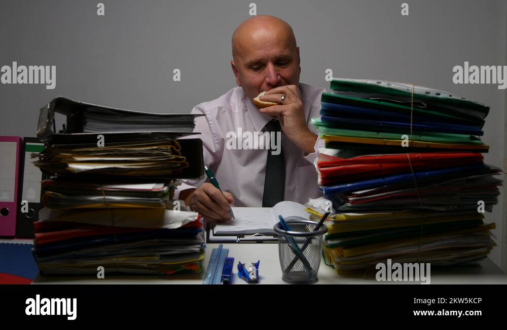 Office Archive Starved Businessman Eating a Sandwich and Write in ...