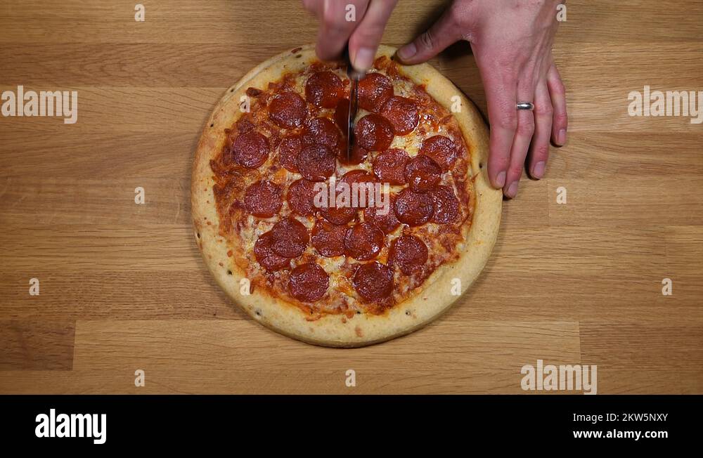 Pepperoni Pizza cut into quarters with a pizza cutter top view Stock ...