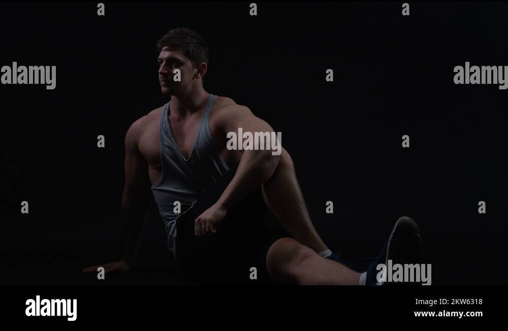 4K Fit young man with muscular physique doing stretches to improve ...