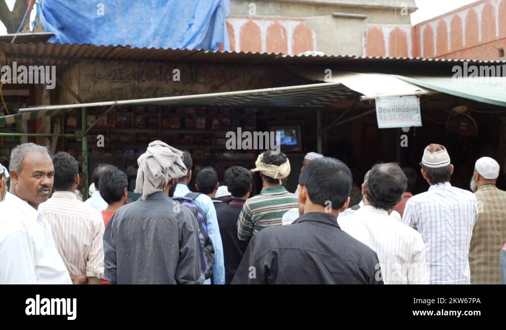Crowd of poor working class Indian men watch small television, Delhi ...