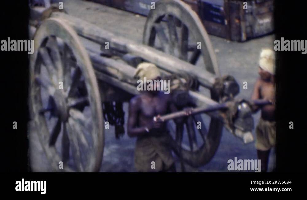 1946: three black men pushing wheeled object down road BOMBAY INDIA ...