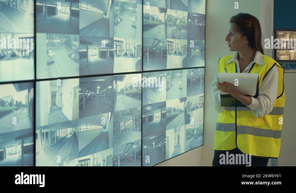 4K Security staff watching screens & discussing in observation control ...