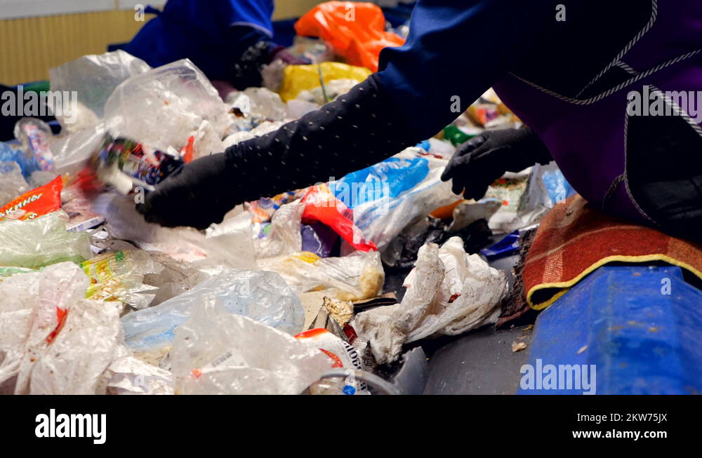 Trash workers sorting trash, garbage at a recycling plant conveyor ...