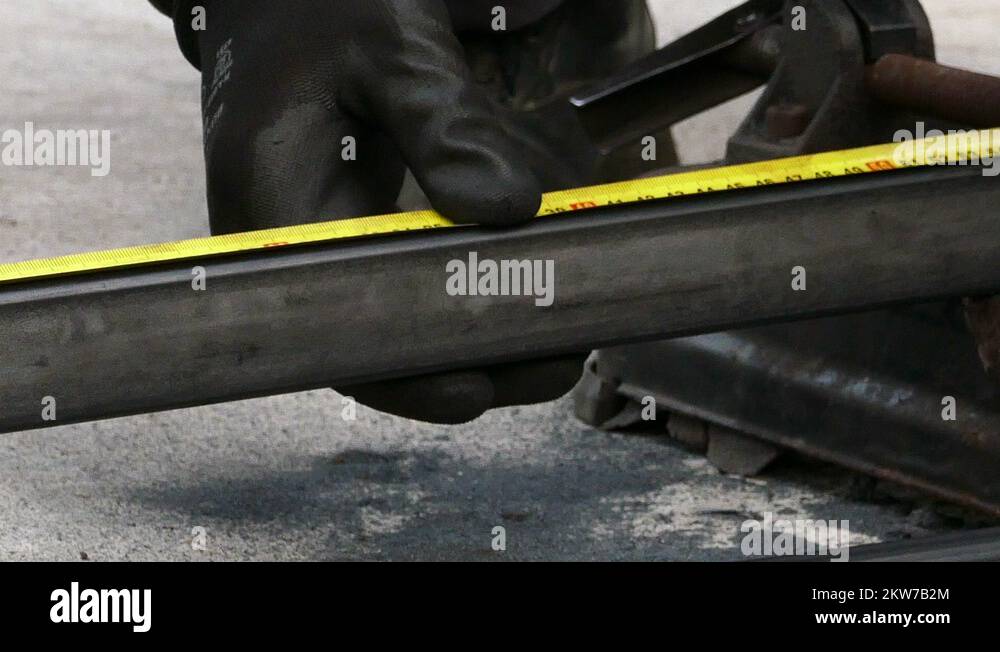 Measuring metal pipe and cutting it off with a lots of sparks, Dolly ...