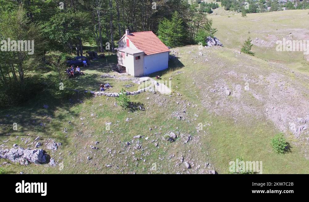 People sitting in front of brick mountain cabin Stock Video Footage - Alamy