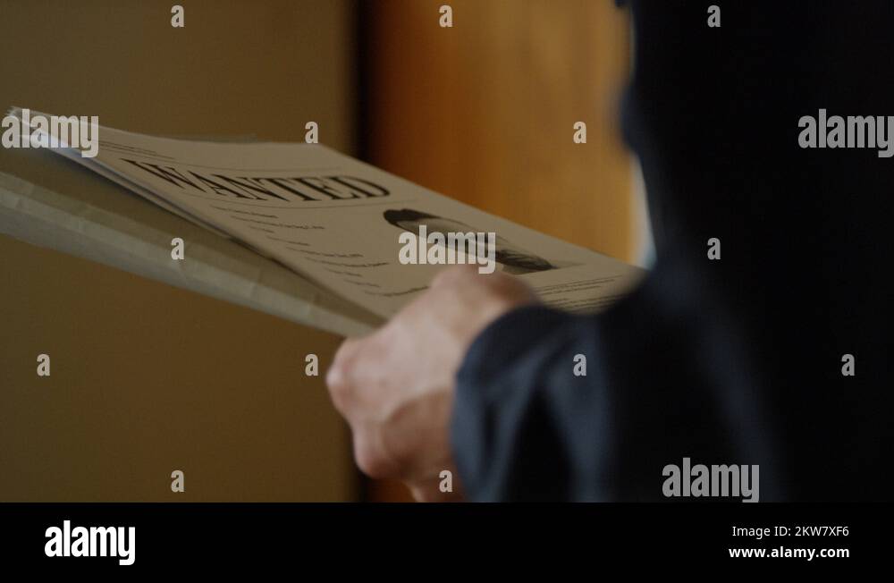 Police officer holding wanted poster in precinct Stock Video Footage ...