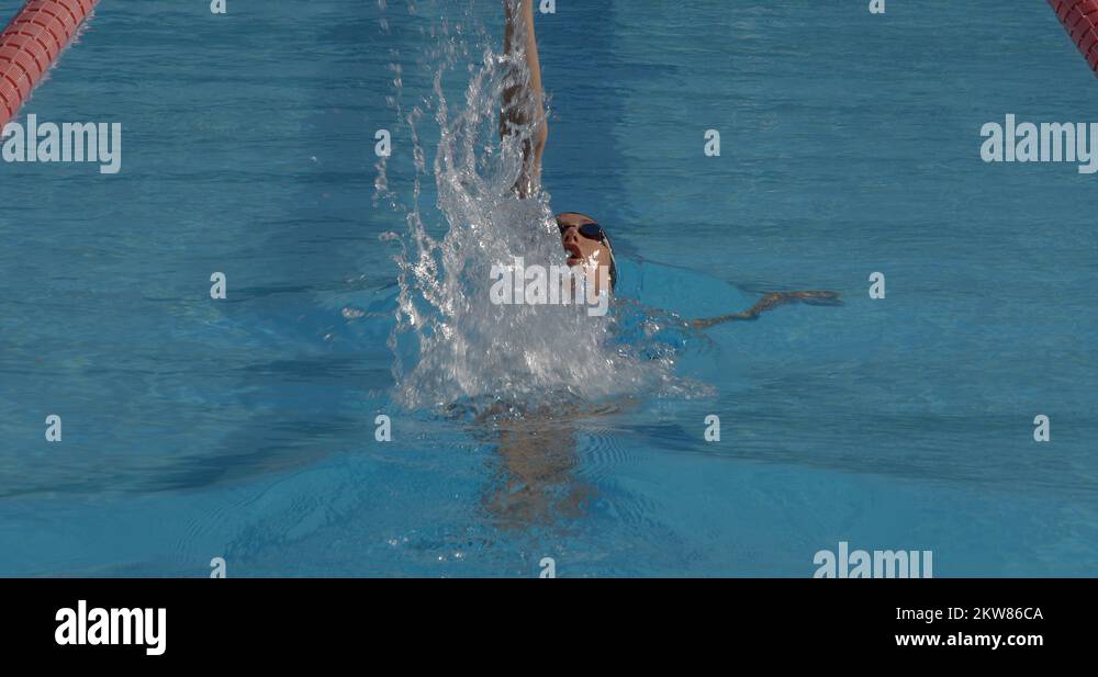 Swimmer Kick Turns and Emerges from the Swimming Pool doing Backstroke ...