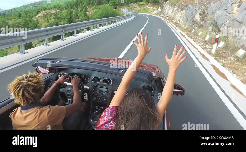 Back view of black men with dreadlocks driving girlfriend in ...