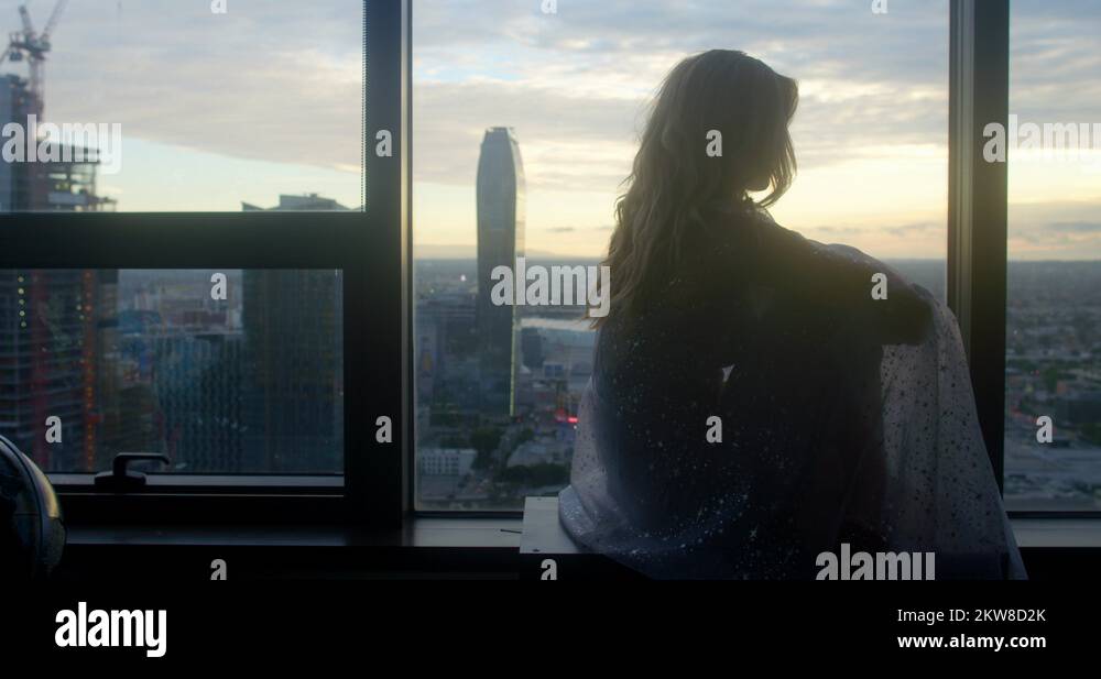 Attractive young woman sits in window overlooking Los Angeles 4K Stock ...