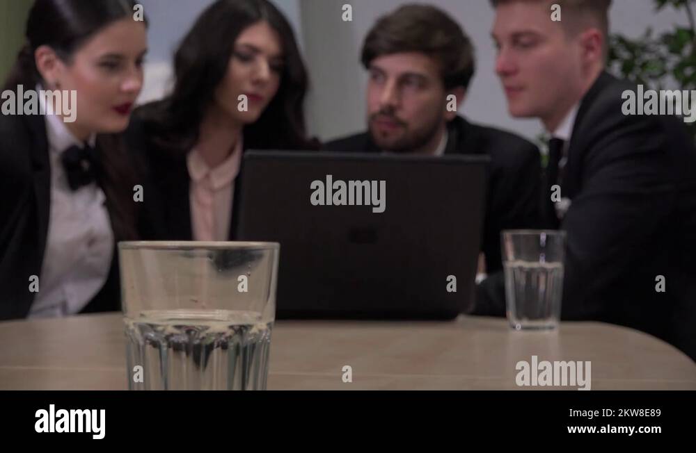 Four business people in front of laptop working talking teamwork water ...
