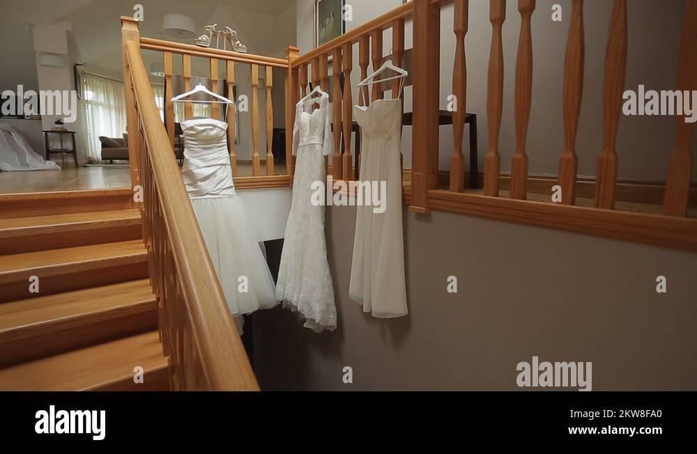 Three wedding dresses on stairs Stock Video Footage - Alamy