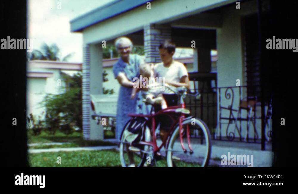 1963: boy watching a baby sitting in the cycle where his grandma left ...