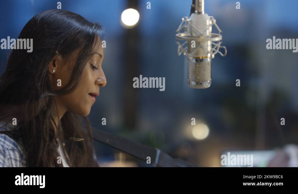 4K Female singer songwriter recording a track in professional studio ...