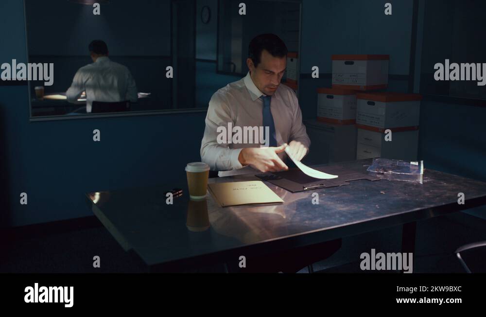 4K Police detective in interview room looking at suspect's file ...