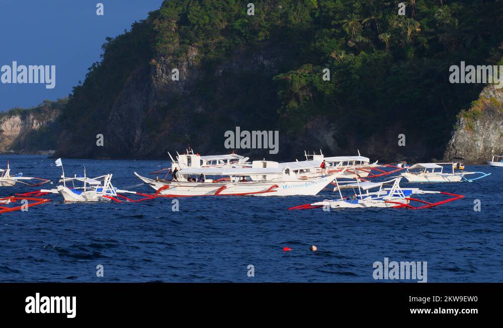 Traditional filipino outriggers on the ocean during sunet in the ...