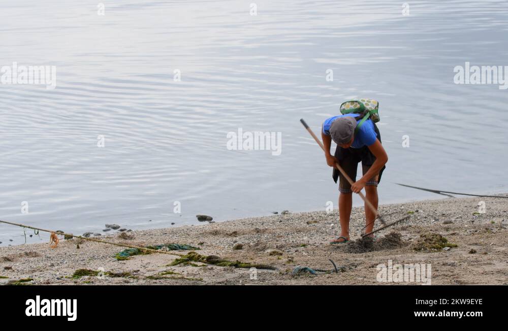 Woman cleaning the beach during sunrise in the Philippines Stock Video ...