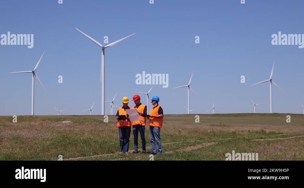 Team of Engineer Men Visiting Wind Turbine Plant Farm Talking Energy ...