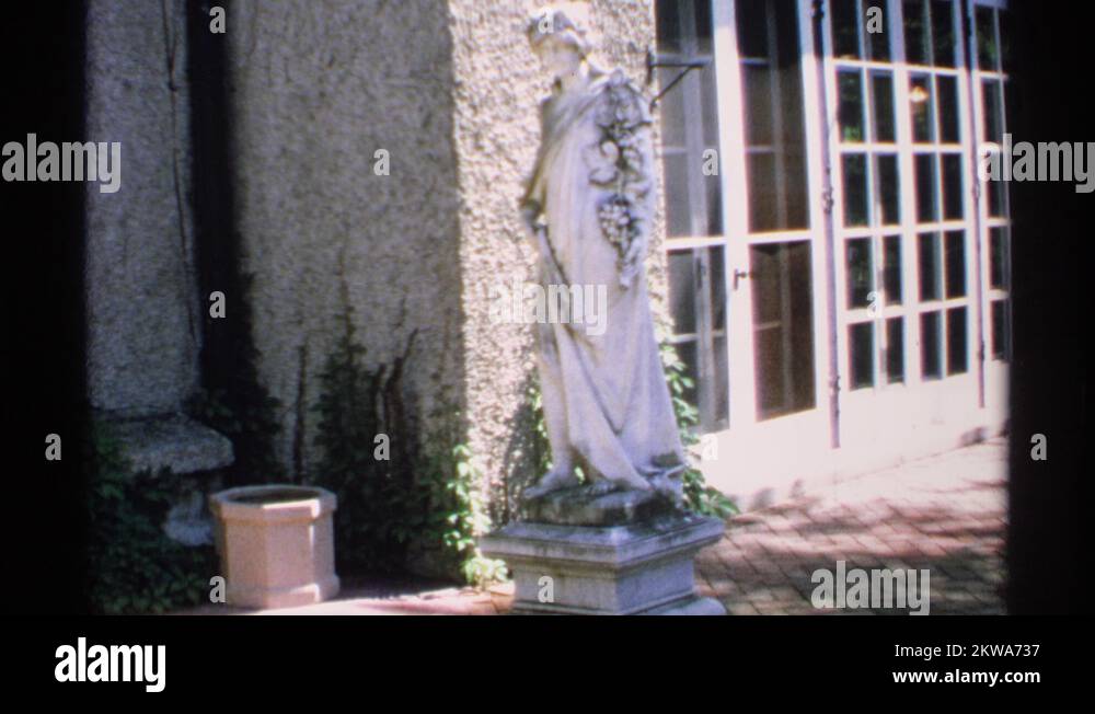 1970: a stone women sculpture is created in front of a luxury house ...