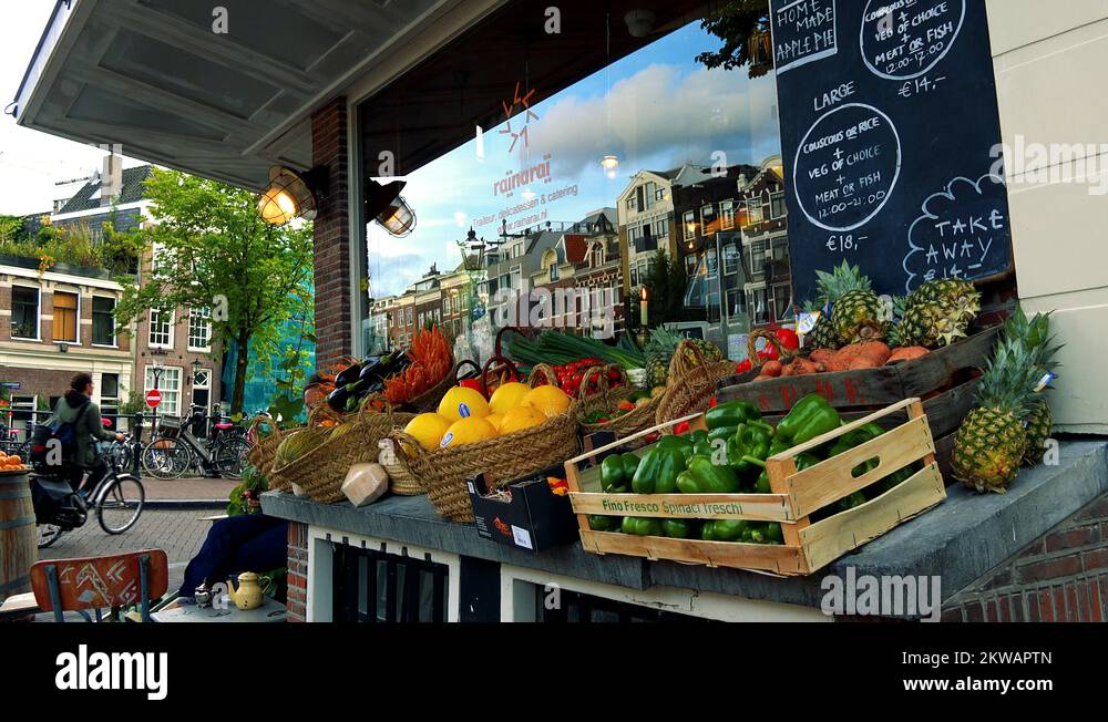Fruit and vegetable in baskets and crates in front of a display window ...