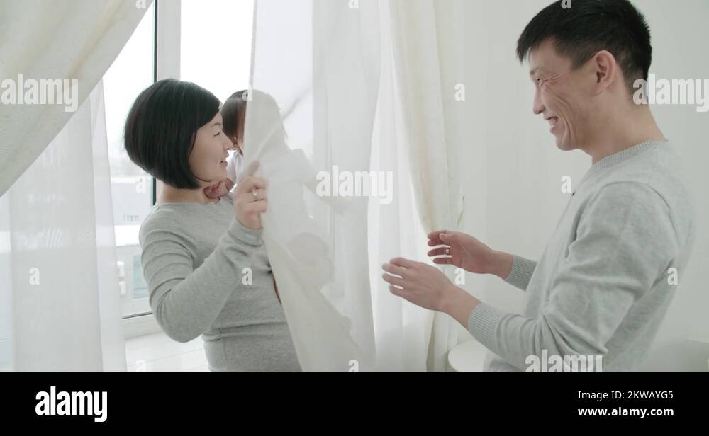 slow motion, a young Asian couple with a little girl in the bedroom ...