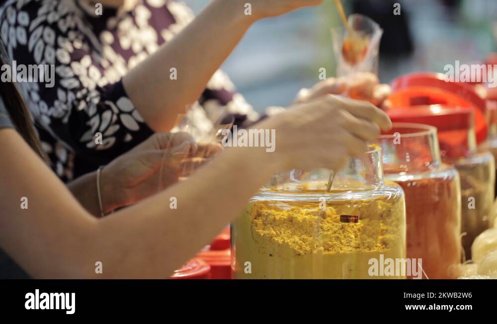 Two young womans choosing spices in grocery section at supermarket ...