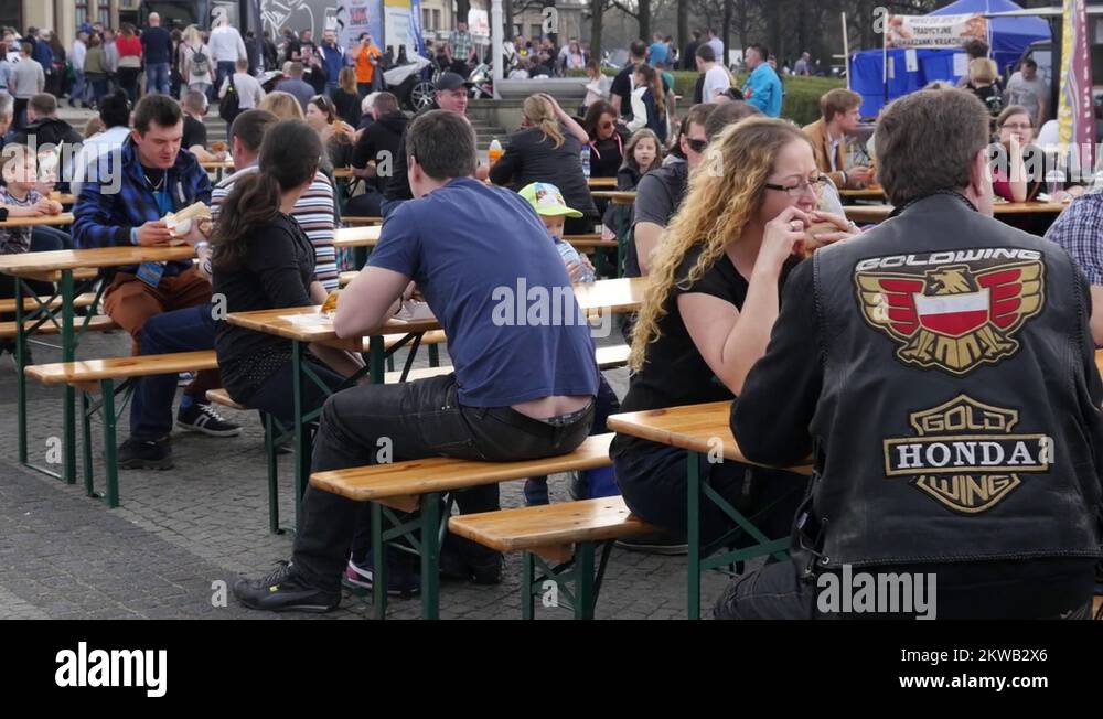 Festival area with food trucks and tables where people enjoy sit eat ...